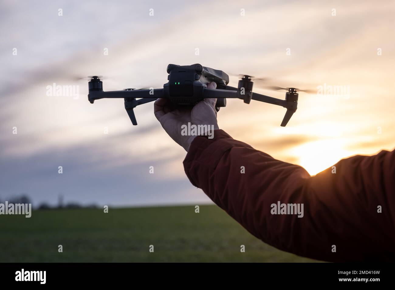 Drone Pilot Launching Drone from Hand at Sunset Stock Photo - Alamy