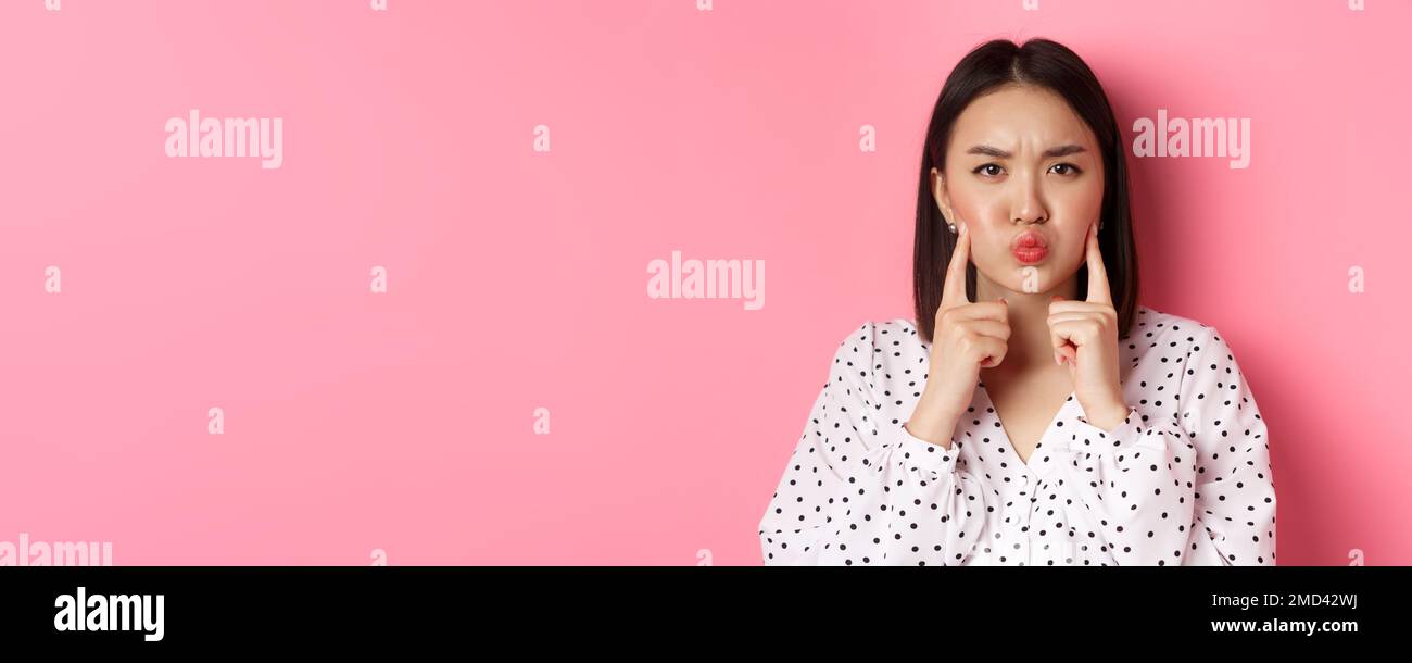 Beauty and lifestyle concept. Cute asian woman making grumpy face ...