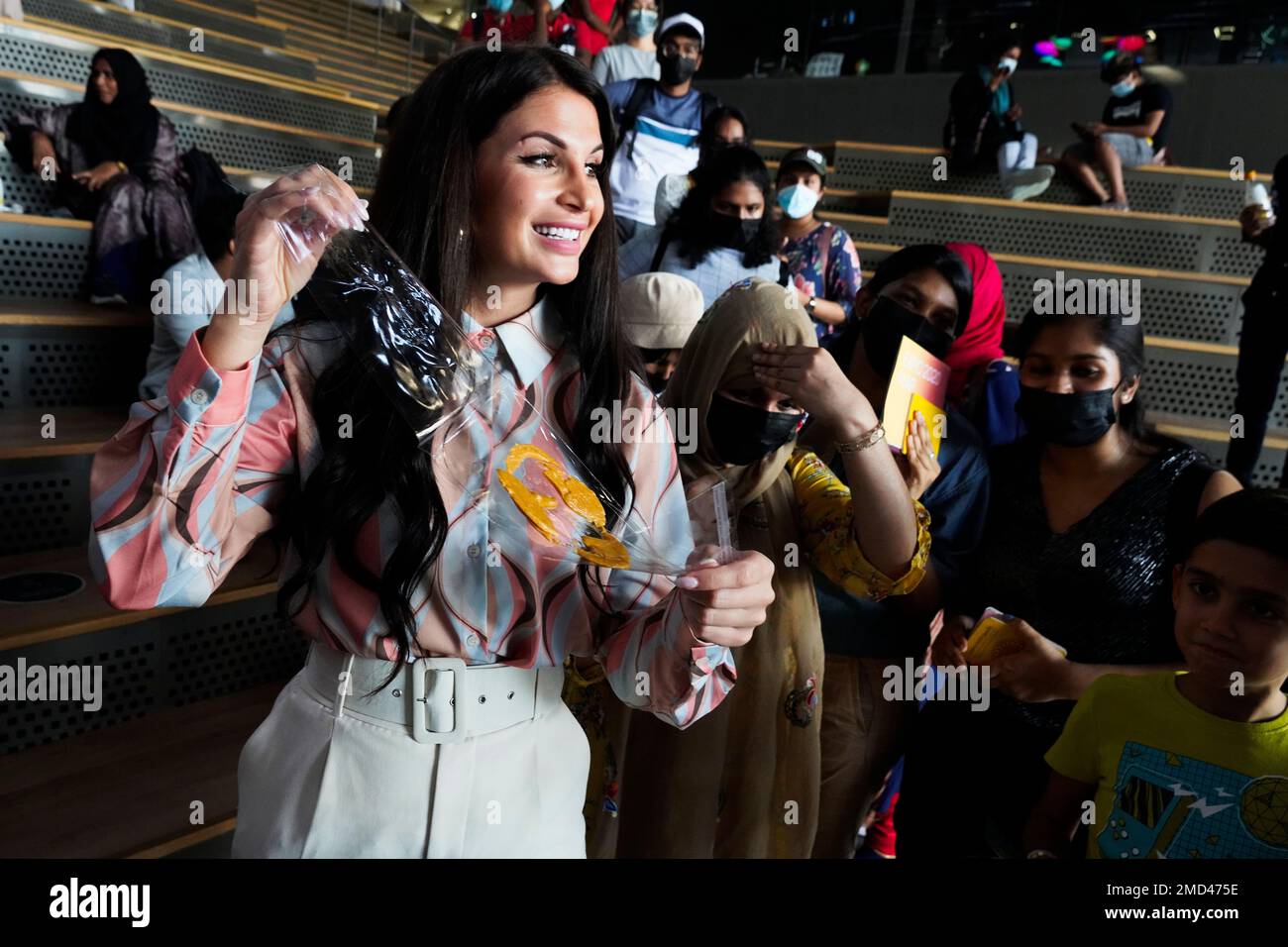A woman poses with her broken candy after playing the game Dalgona at ...