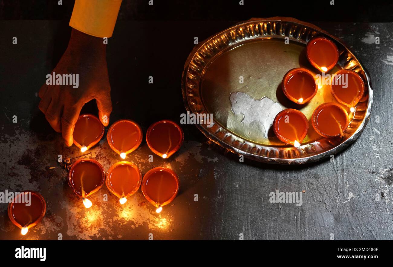 A Sri Lankan ethnic Tamil man offers a tray of oil lamps during Diwali ...