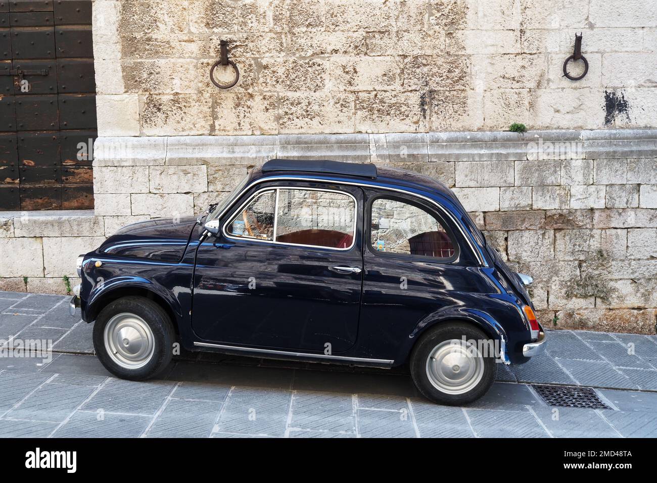 iconic Italian car 'Fiat 500' parked in the medieval village of Gubbio ...
