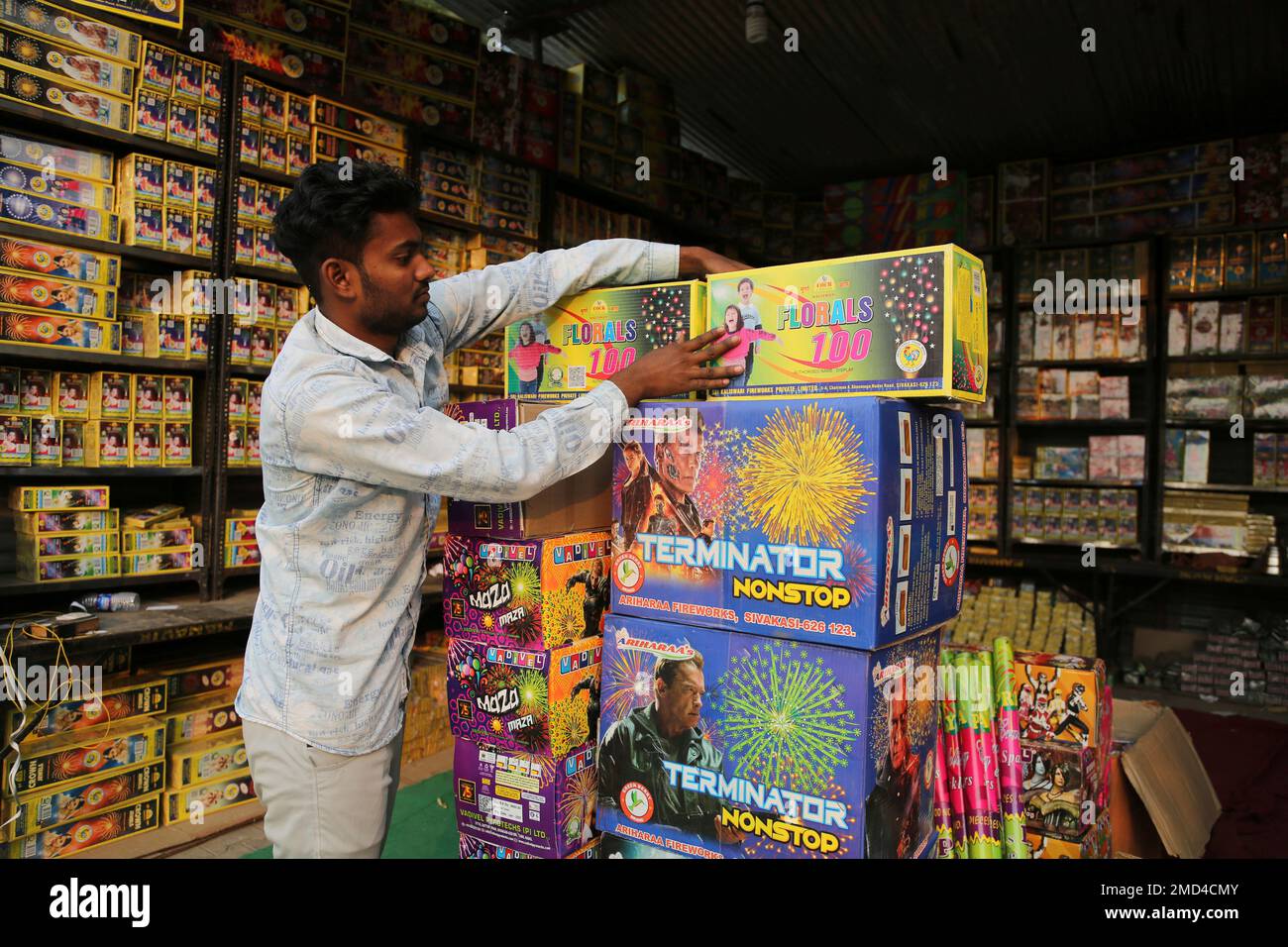 A man arranges packets of firecracker for sale on the eve of Diwali ...