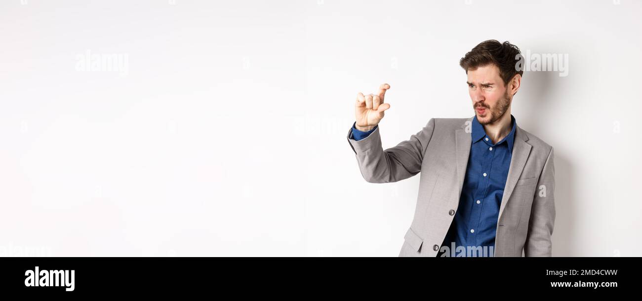 Businessman trying to see something small, showing little thing size ...