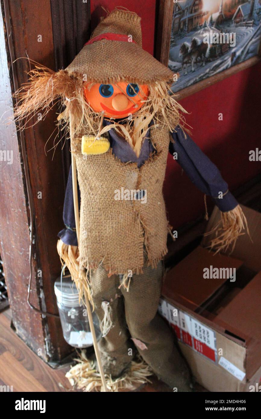 A vertical shot of the straw puppet with a straw hat and clothes and an ...