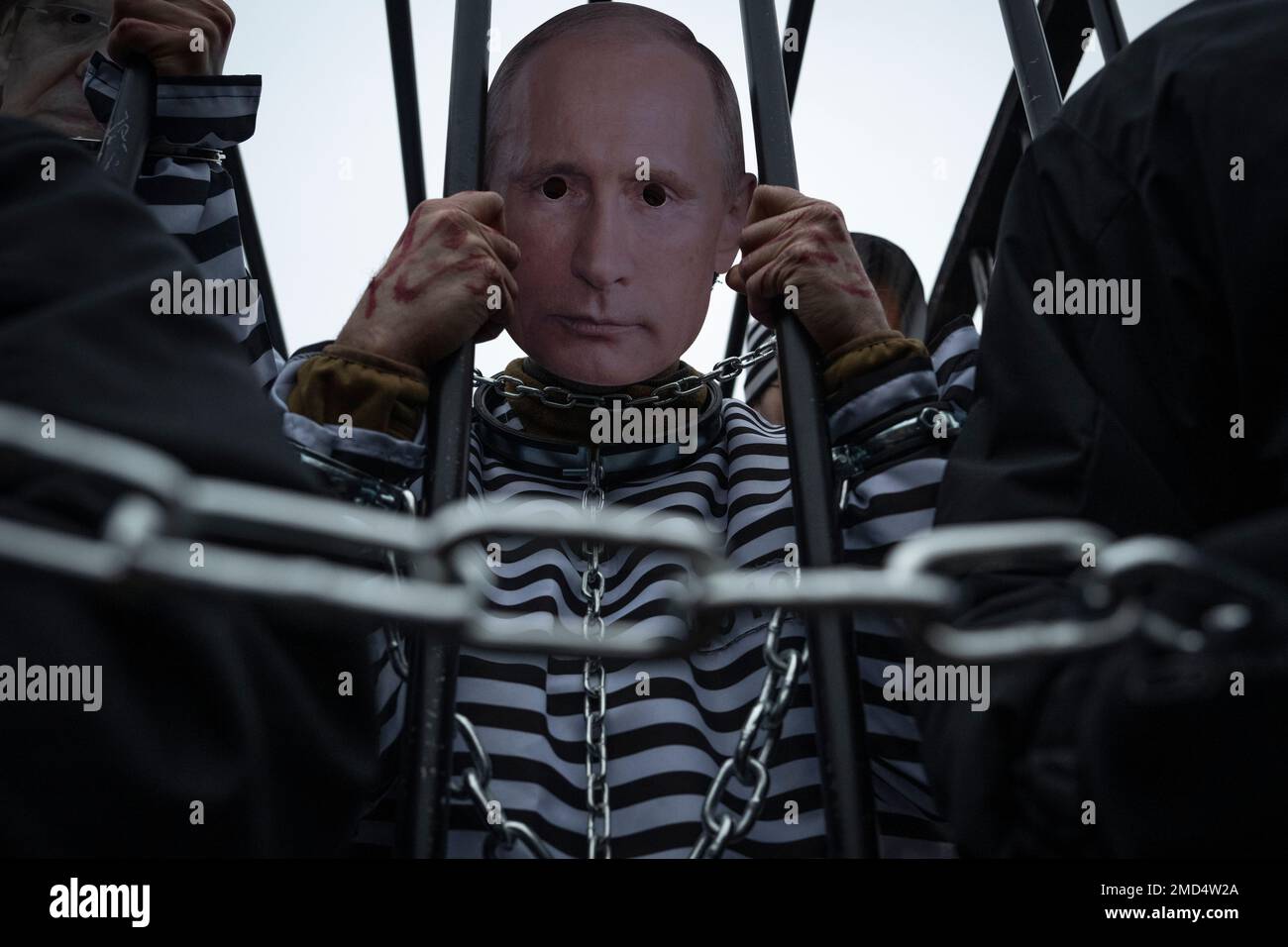 A man in prison overals wearing a Vladimir Putin mask is seen during a ...