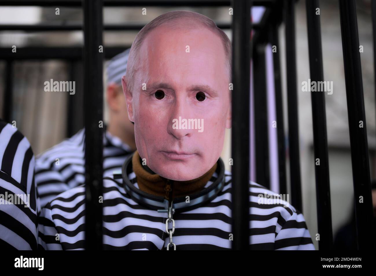 A man in prison overals wearing a Vladimir Putin mask is seen during a ...