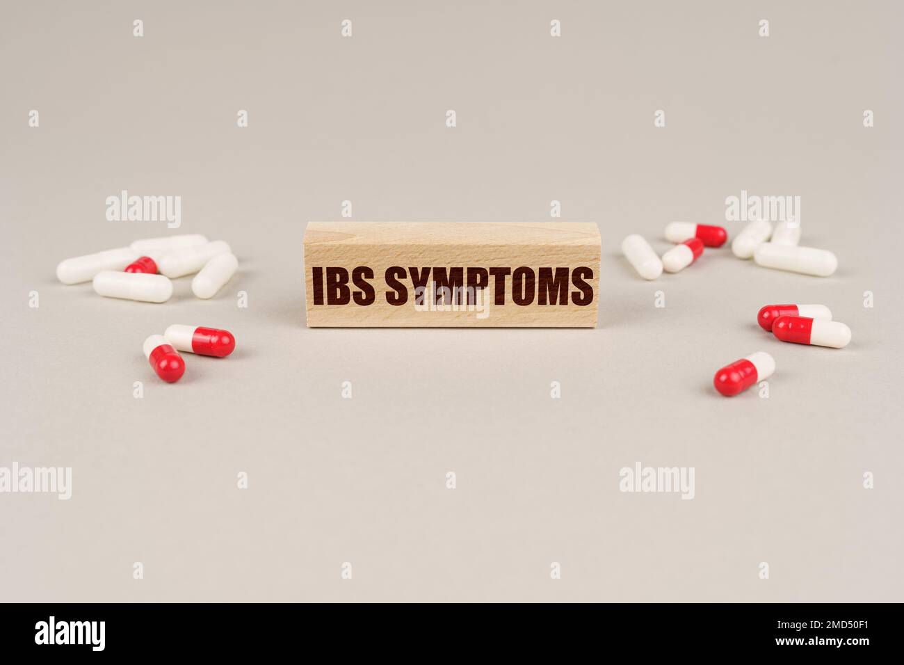 Medical concept. On a gray surface are tablets, capsules and a wooden ...