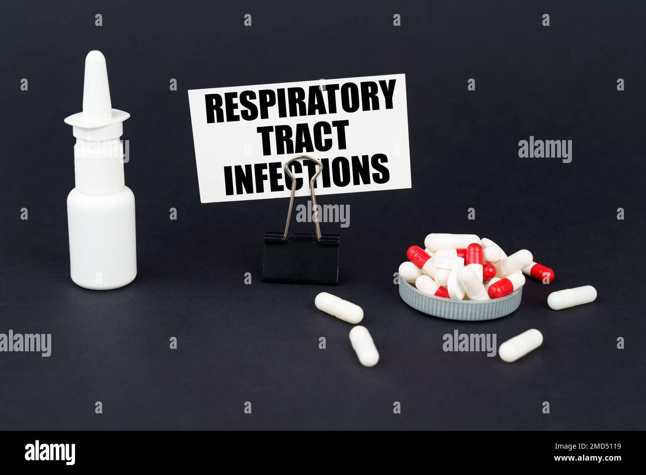 Medical concept. On the black surface of a pill, a nasal spray and a ...