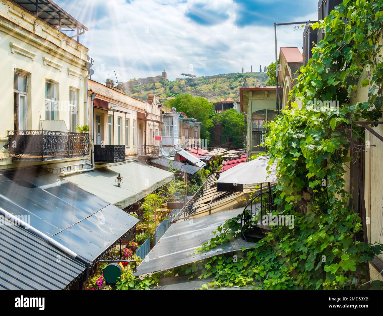 Street in Tbilisi old town with restaurants, balconies and roofs. View ...