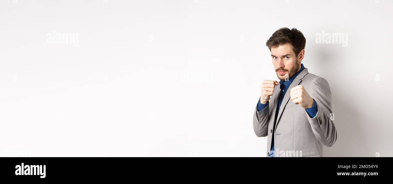 Serious man in suit raising hands in boxer pose, going to fight ...