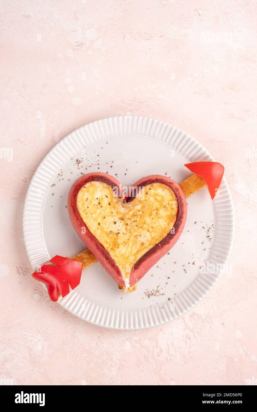 Romantic breakfast. Fried eggs in heart shaped sausages Stock Photo - Alamy