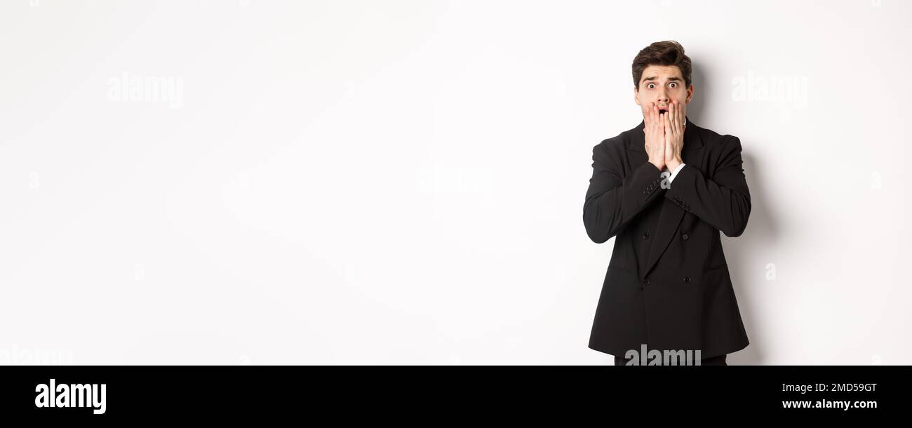 Image of concerned and scared man in black suit, gasping and looking ...