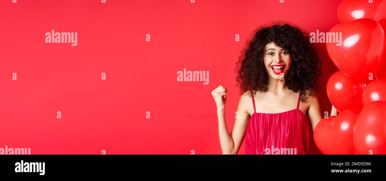 Excited pretty woman winning, say yes and smiling, celebrating success ...