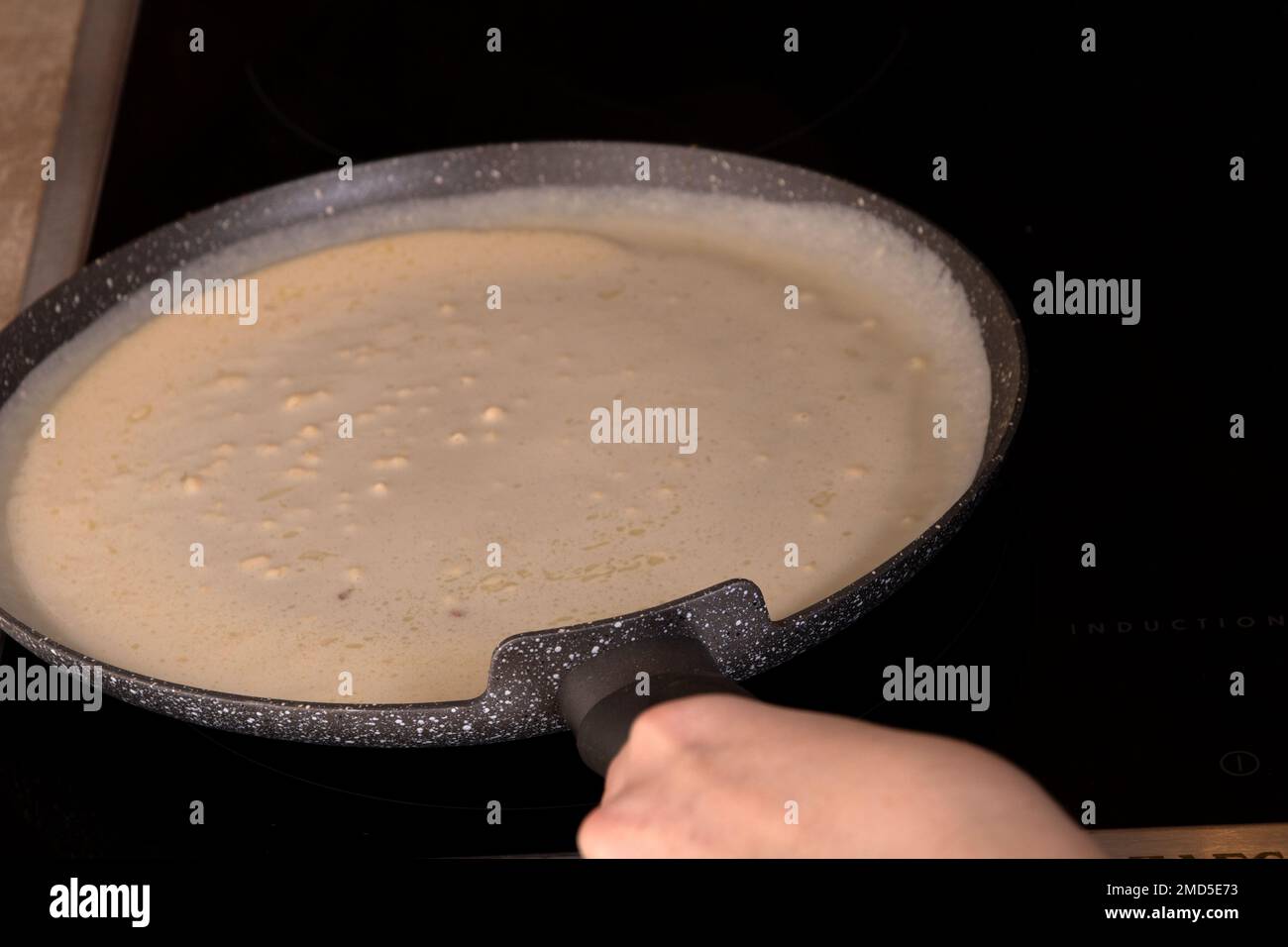 photo preparation of thin pancakes in a pan in the kitchen, on the ...
