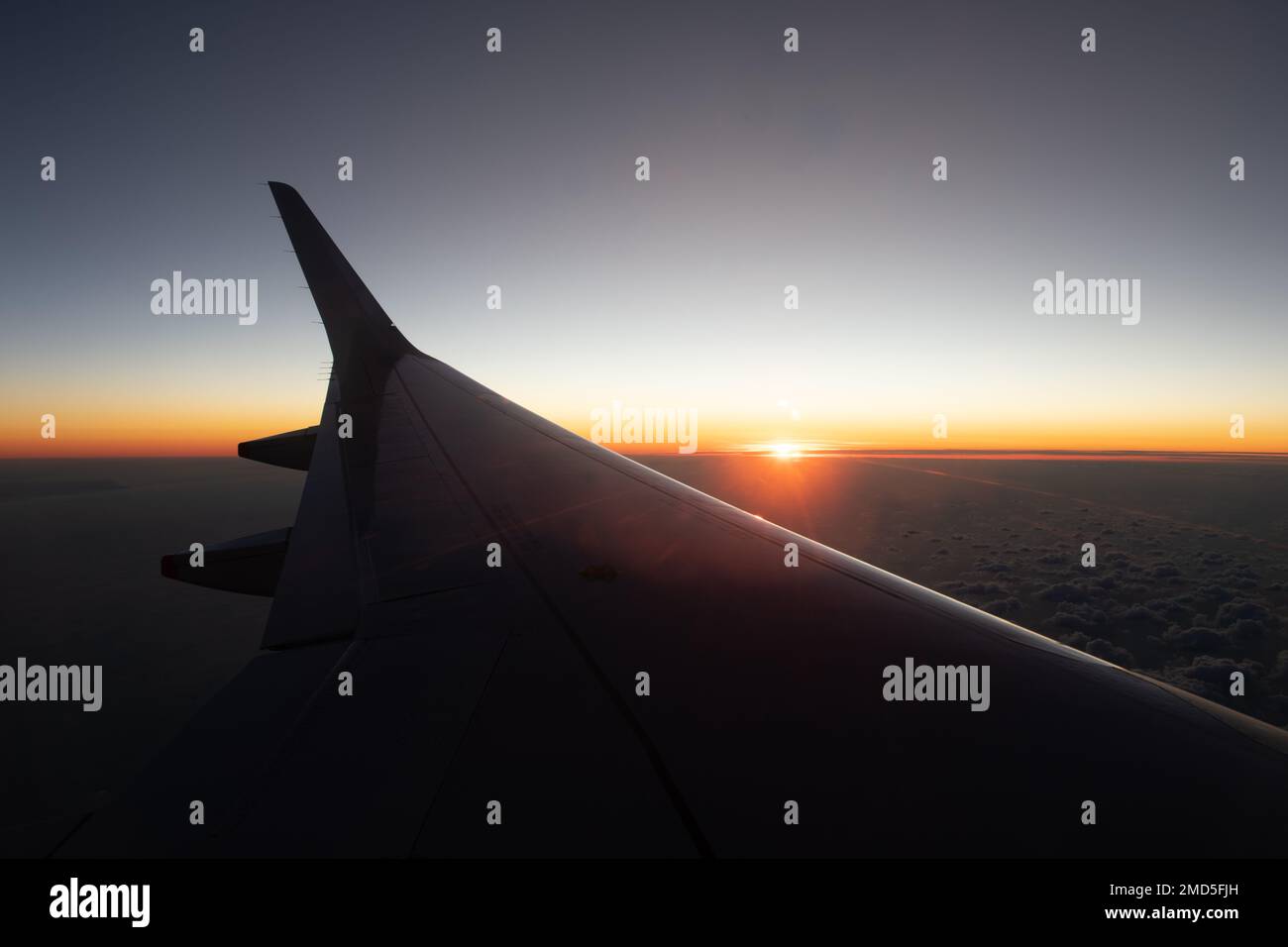 In flight sunset over jet plane wing Stock Photo - Alamy