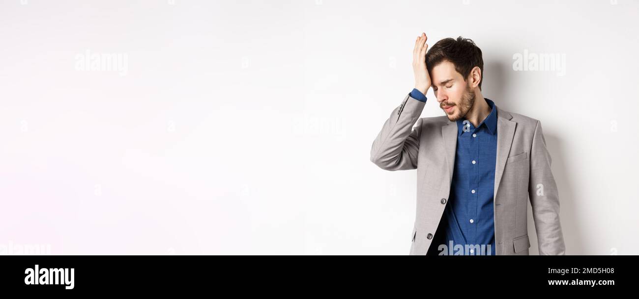 Annoyed businessman in suit facepalm with eyes closed, bothered by ...