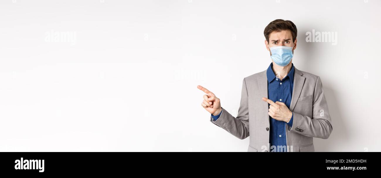 Covid-19, pandemic and business concept. Upset man in medical mask and ...