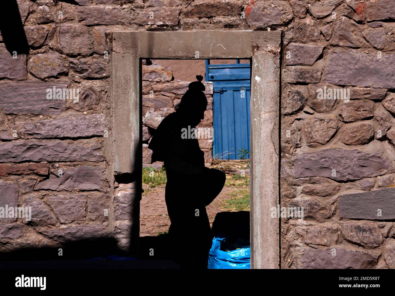 A resident is silhouetted inside the courtyard of his home, in the ...