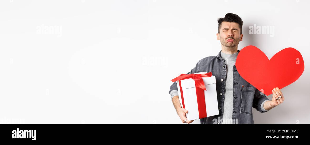 Sad and heartbroken man being rejected, crying and holding red heart ...