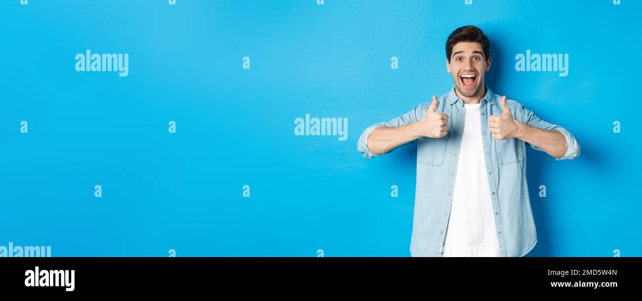 Smiling adult man showing thumbs up with excited face, like something ...