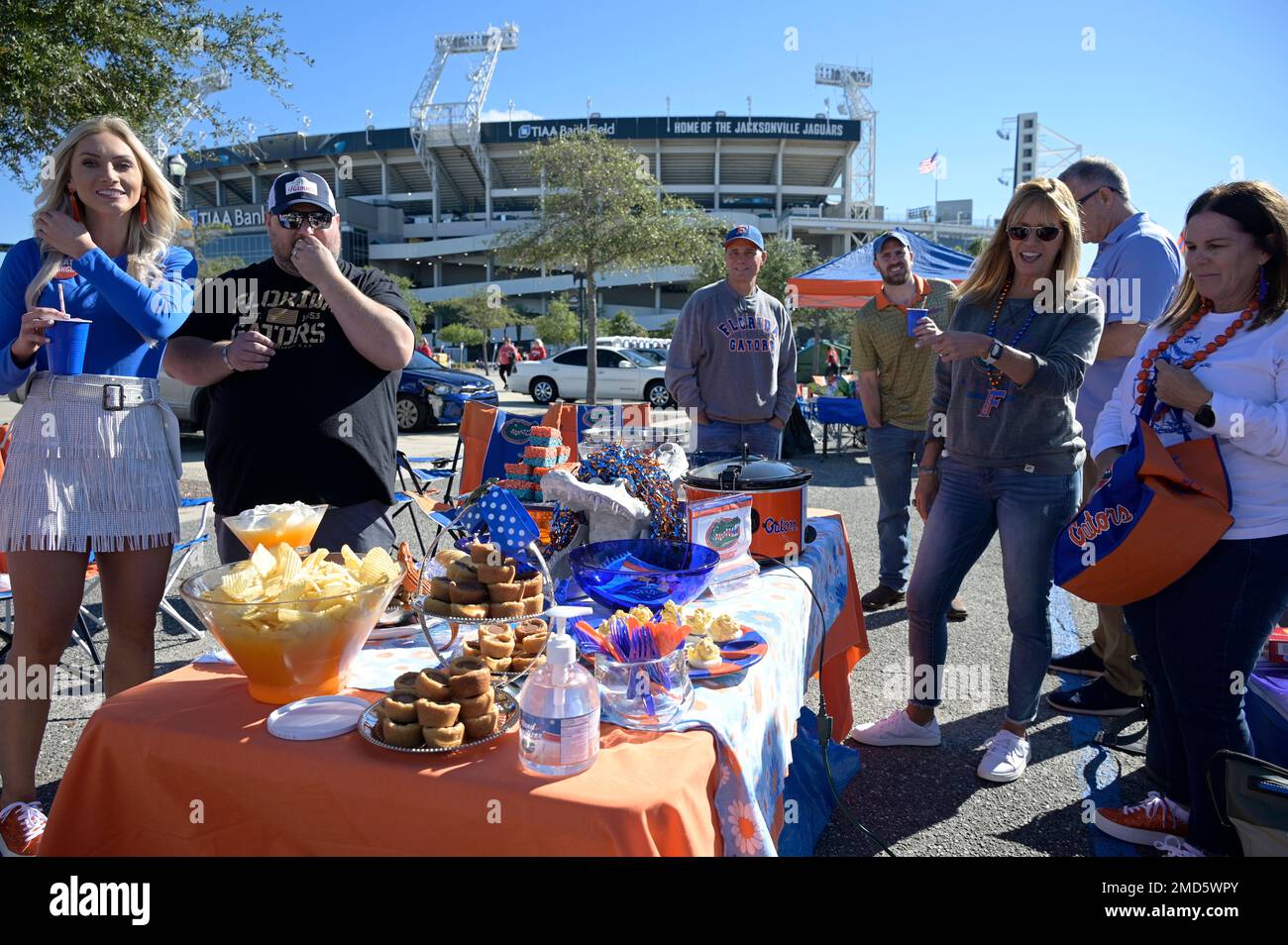 Fan gather in a parking lot outside the stadium before an NCAA college ...
