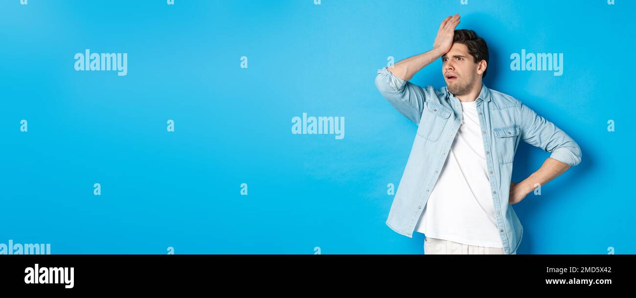 Upset man making facepalm and looking away concerned, forgot something ...