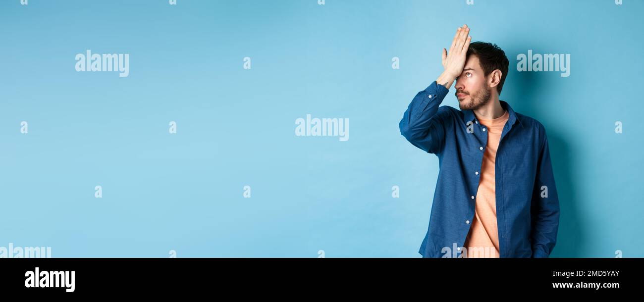 Annoyed and tired man facepalm, roll eyes and look bothered by stupid ...