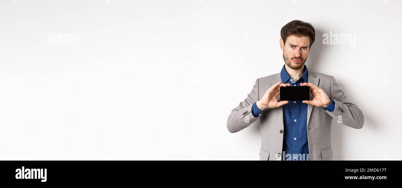 E-commerce and online shopping concept. Hesitant frowning man showing ...