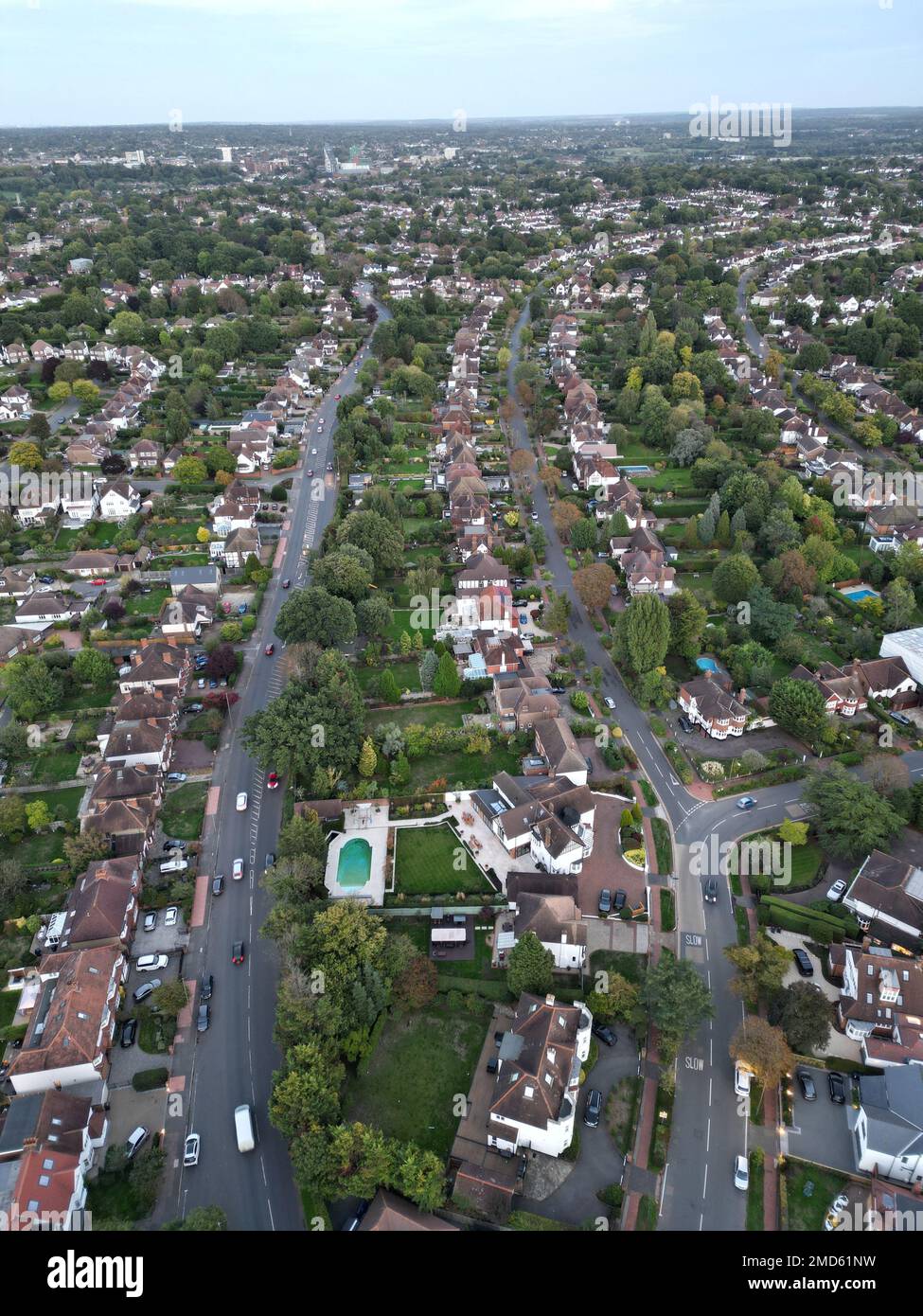 A high-angle shot of a city full of buildings, green trees, fields and ...