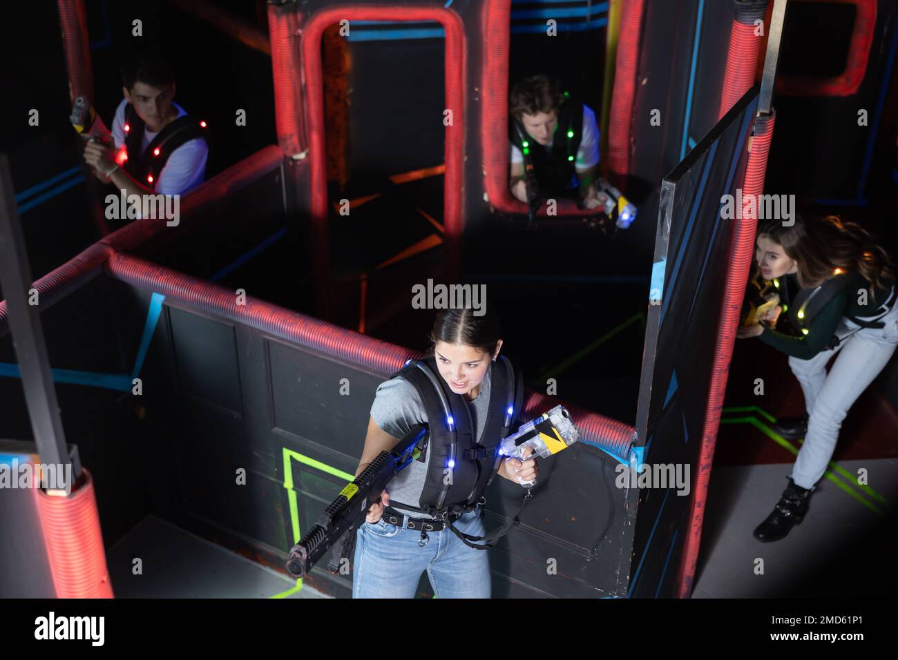 Four people playing lasertag in labyrinth arena Stock Photo - Alamy