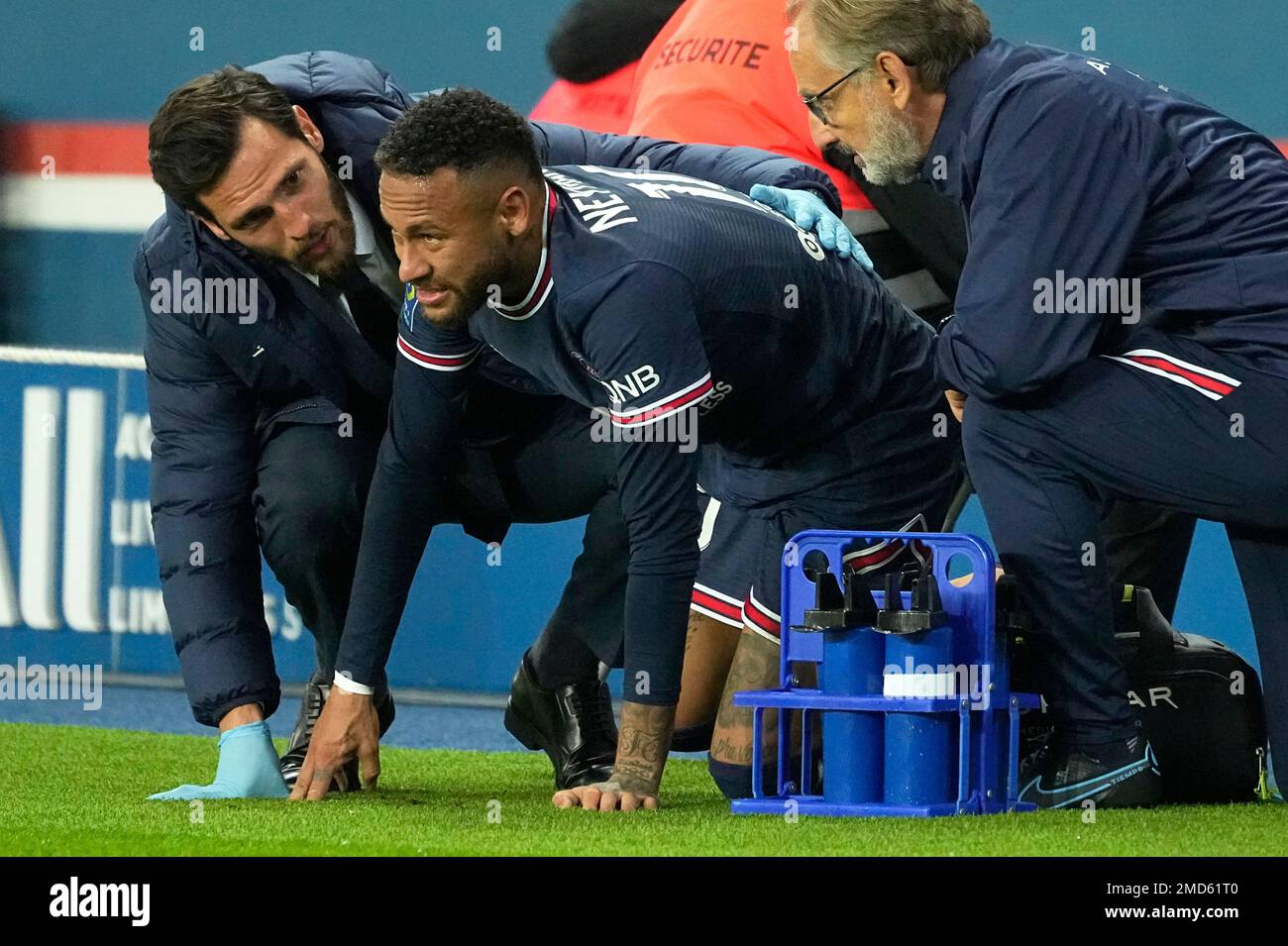 PSG's Neymar, centre, receives medical attention during French League ...
