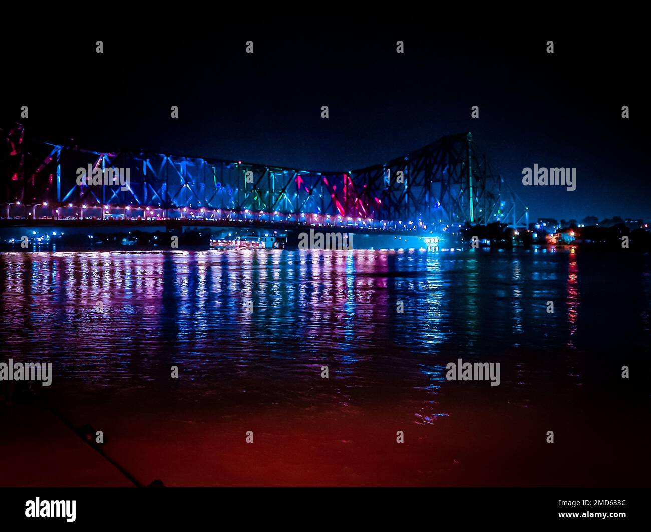 A beautiful view of the colorful Howrah Bridge lights reflected in the ...