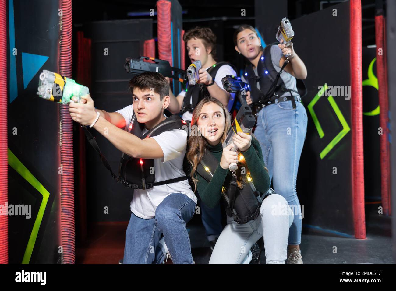Girls and guys playing laser tag game opposite each other in modern dark room Stock Photo - Alamy