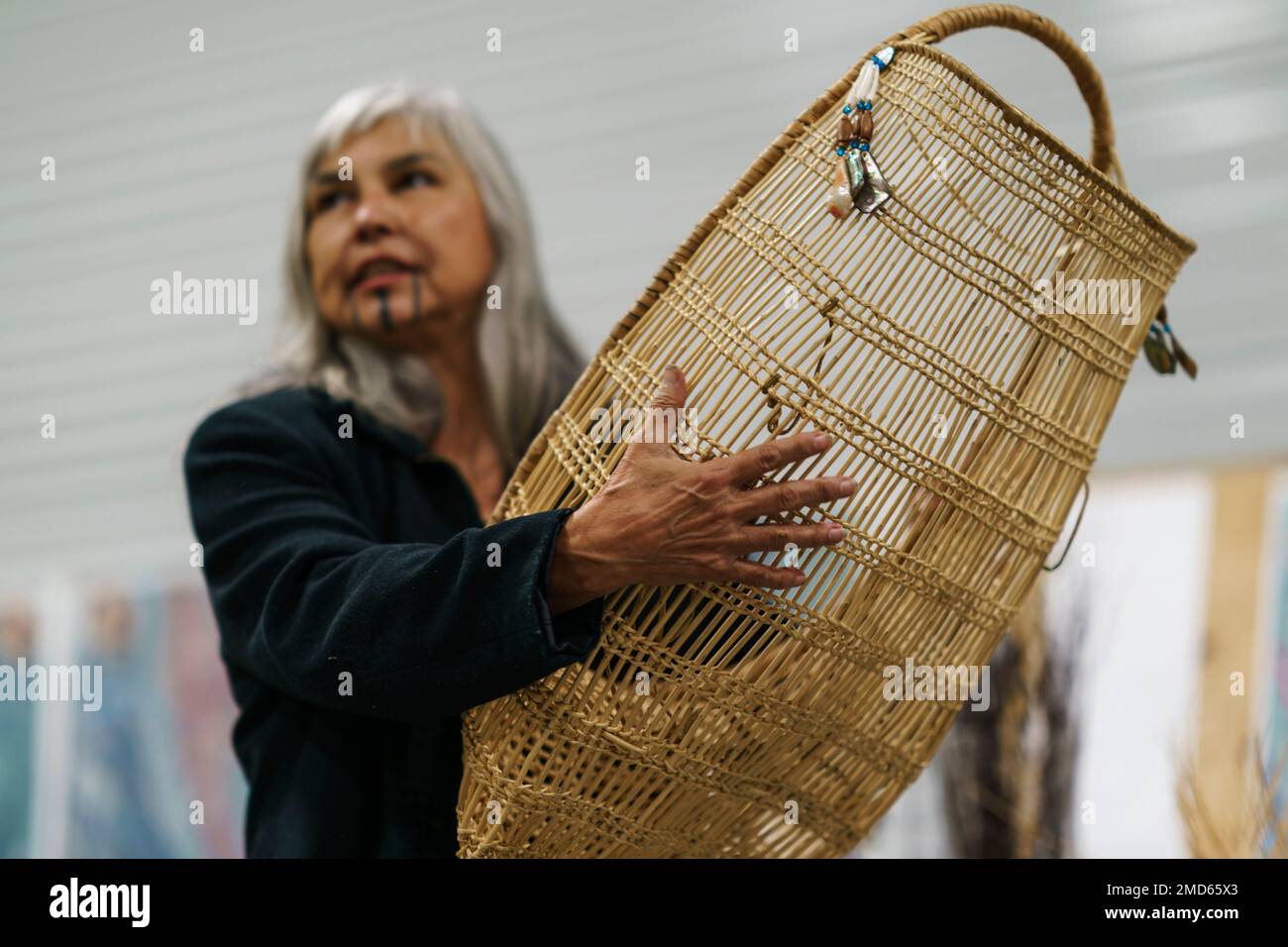 Margo Robbins shows off a baby basket she made out of hazel wood to ...