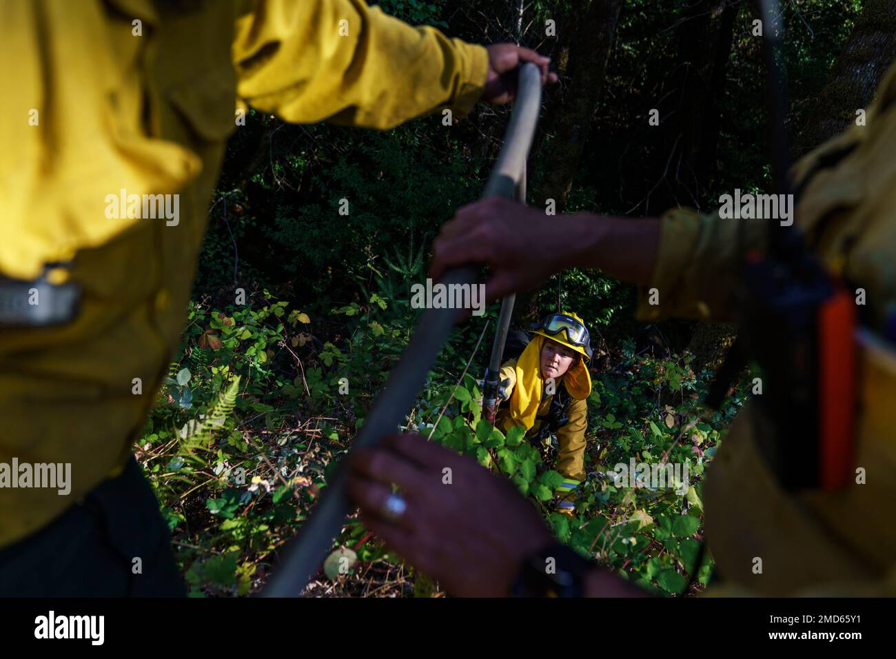 Mae McLean with Cal State Parks climbs down a hill to extinguish a ...
