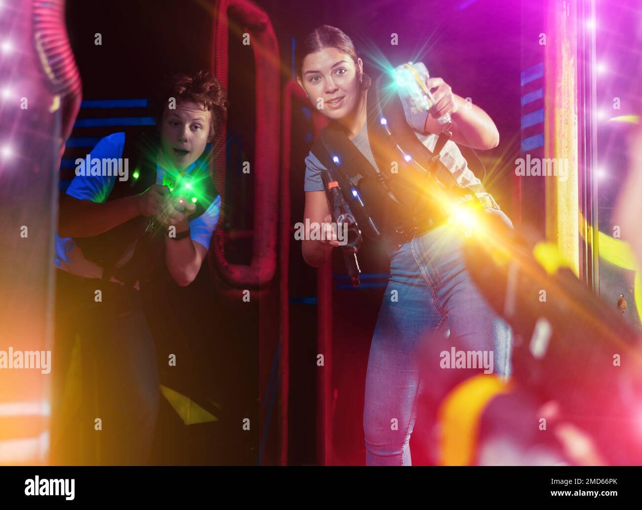 Two players guy and woman with laser weapons in dark laser tag room ...