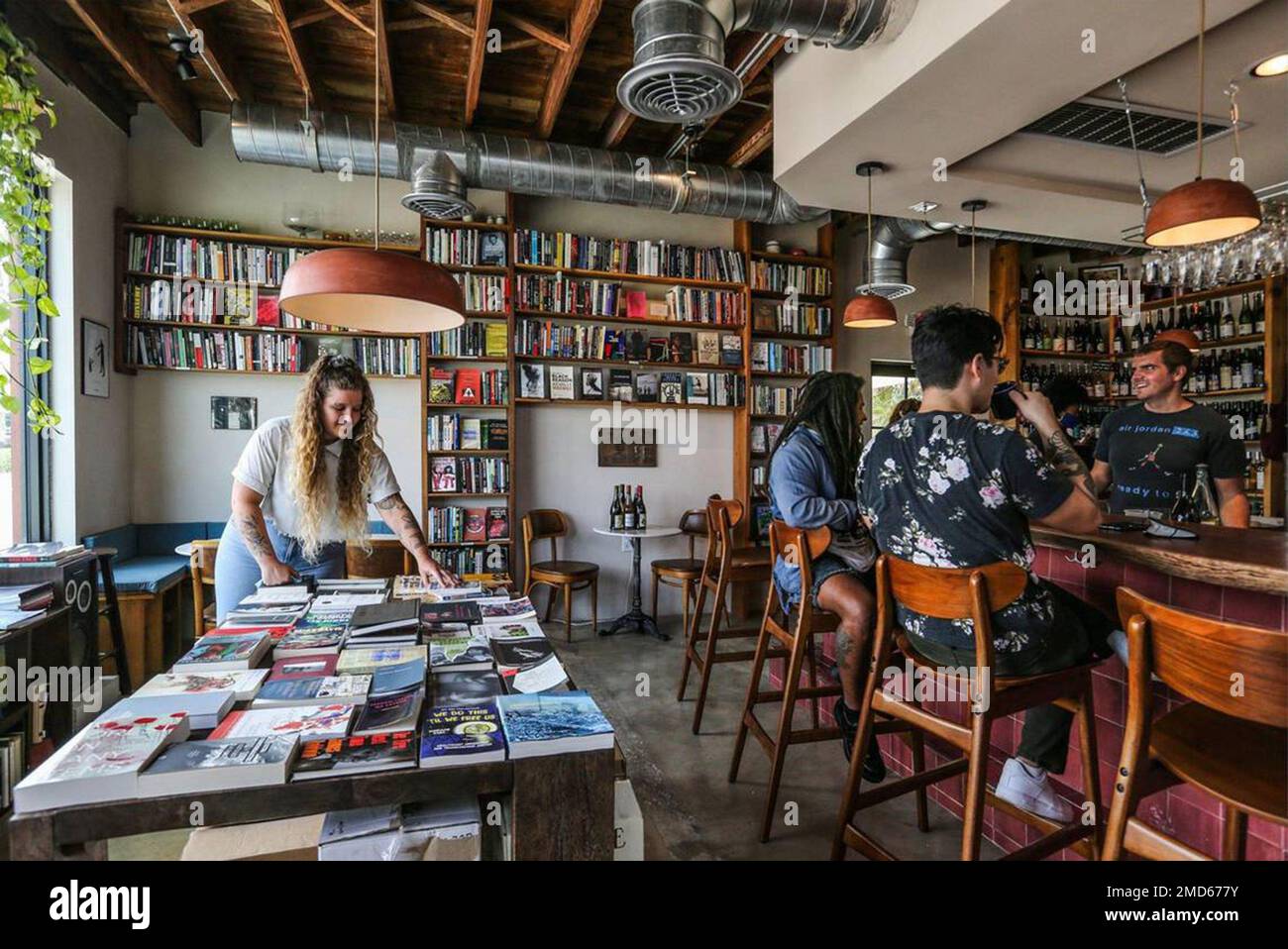 Audrey Wright unpacks books as Sef Chesson, Ben Yen and Brian Wright drink coffee at Paradis ...