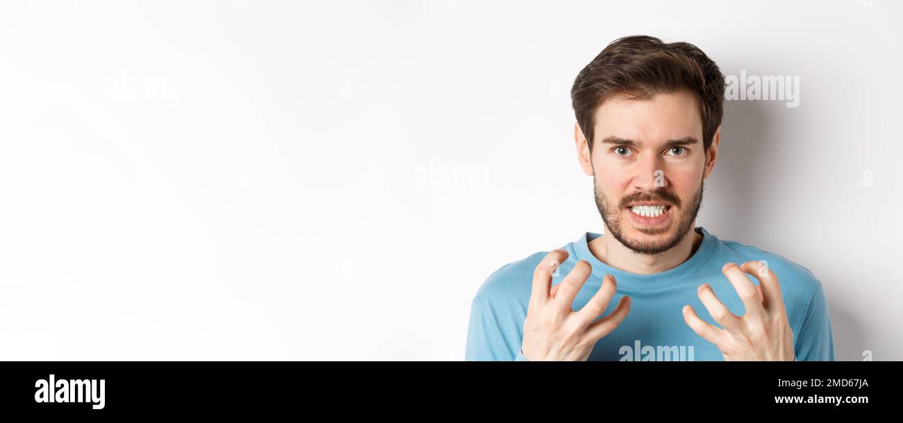 Close up of angry young man with beard, shaking hands mad, squeeze ...
