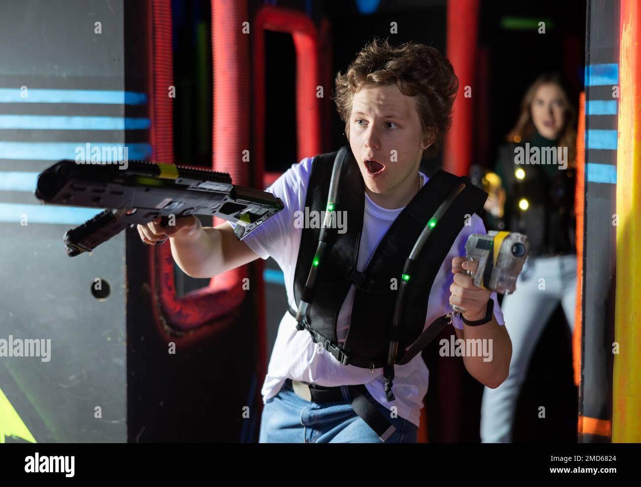 Portrait of man with laser gun having fun with family on laser tag ...