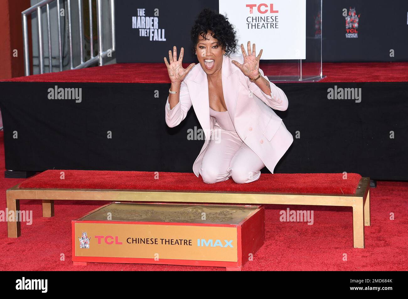 Regina King poses for photos after placing her hands in cement during a ...