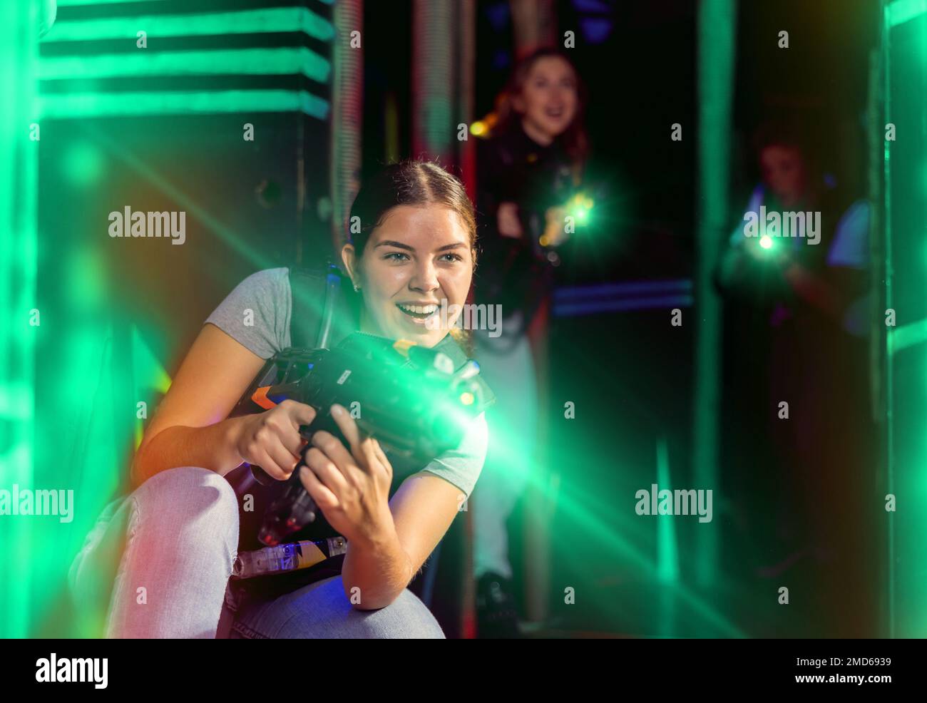 Girl running and dodging while playing lasertag Stock Photo - Alamy