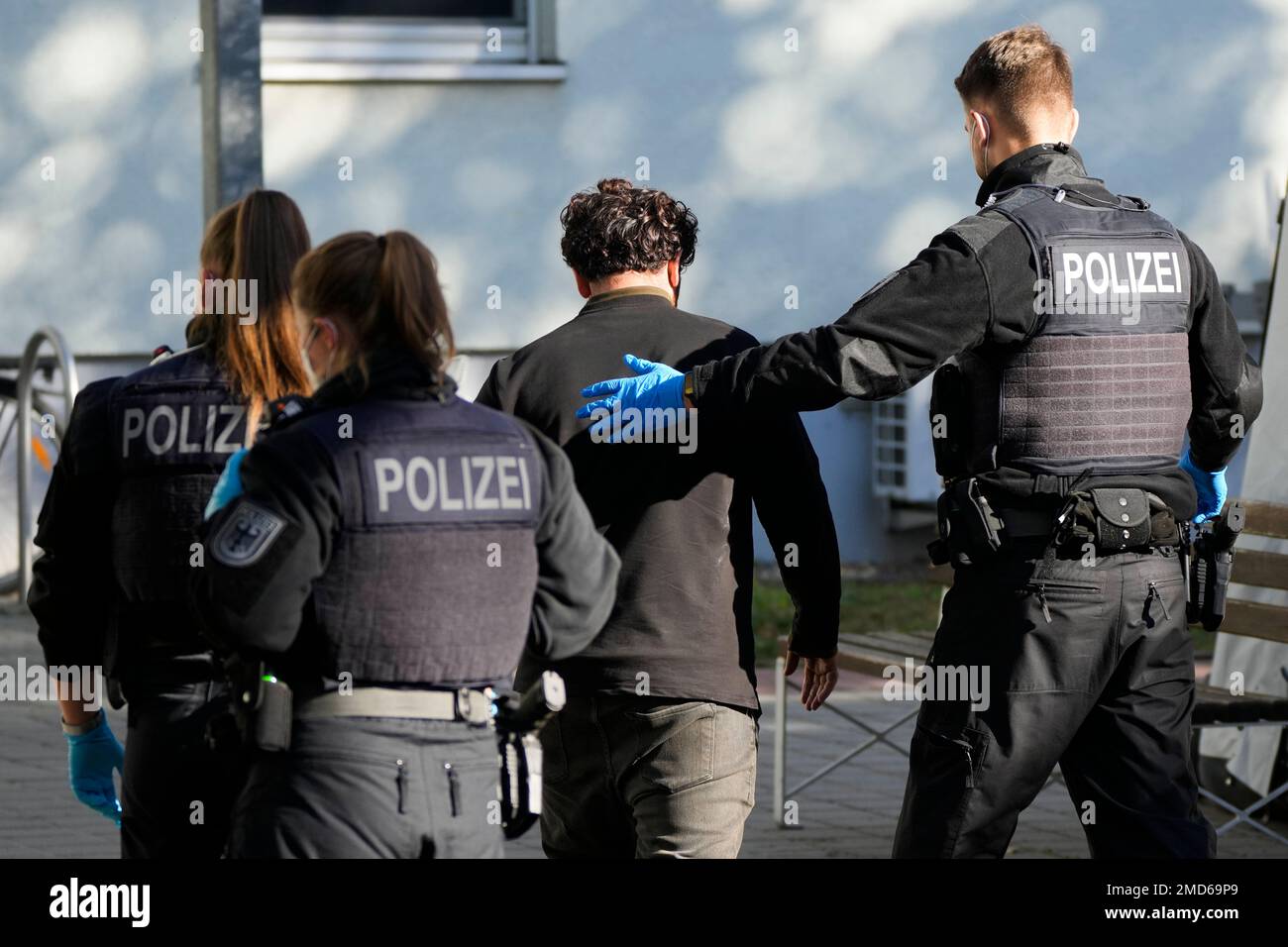 Federal police officers guard an arrested migrant at a police station ...