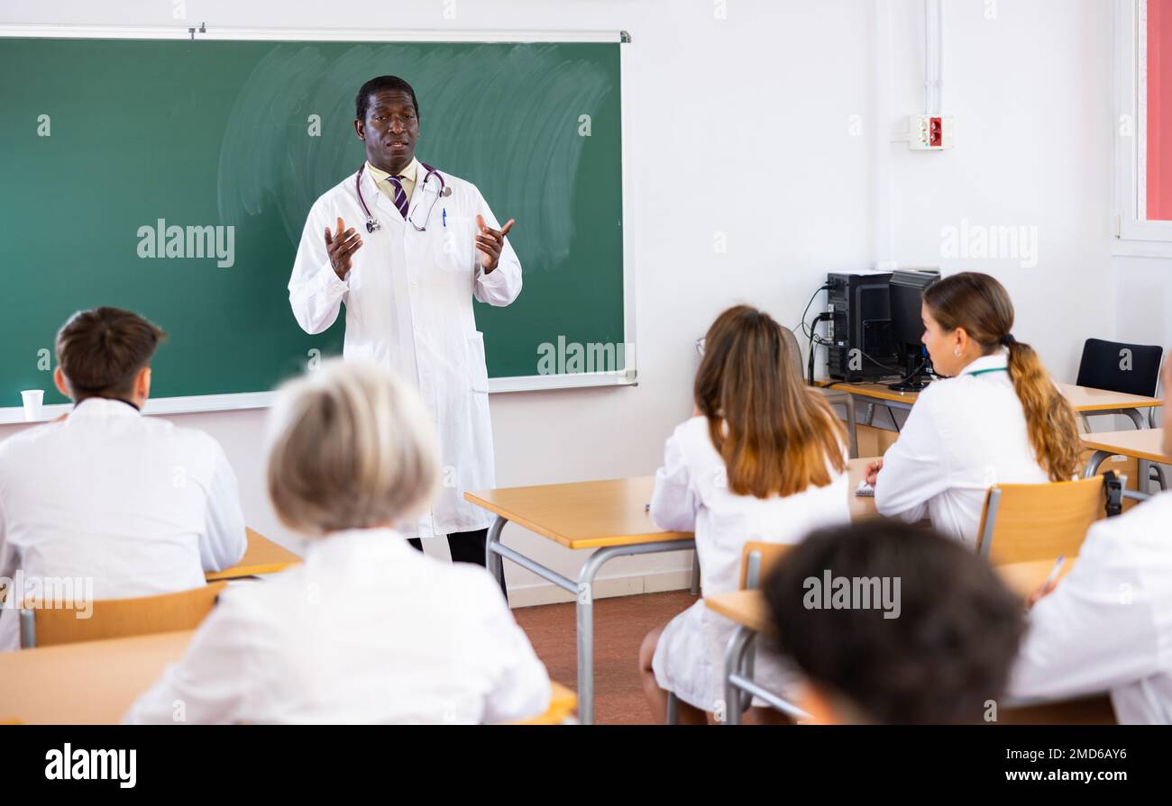 African american male doctor explaining new theme to adult students ...