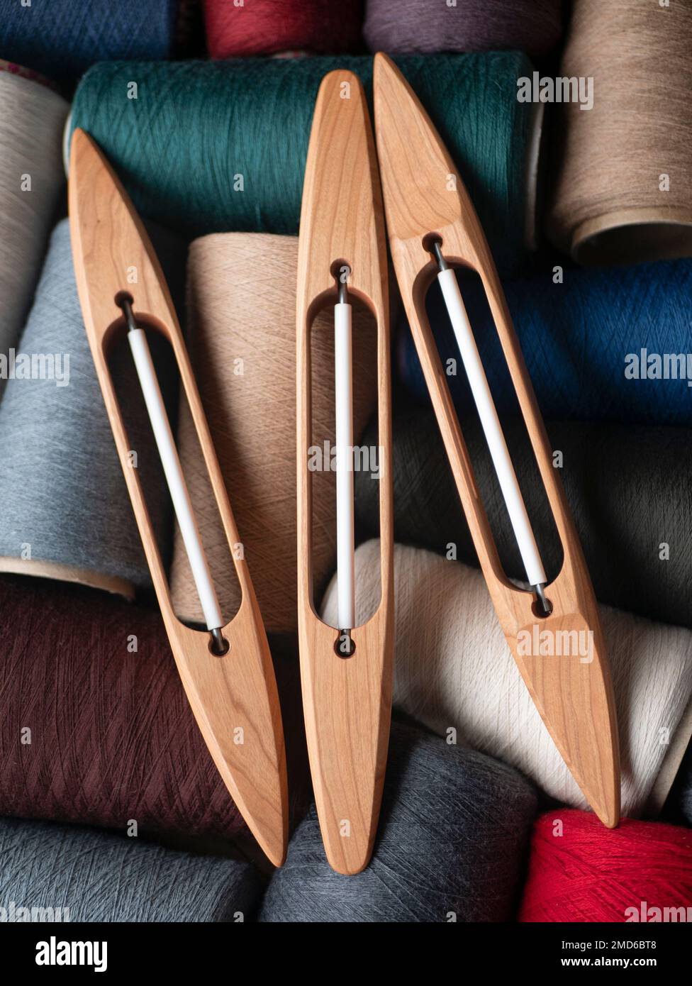 Wooden boat shuttles and bobbins with colored yarn, selected focus ...