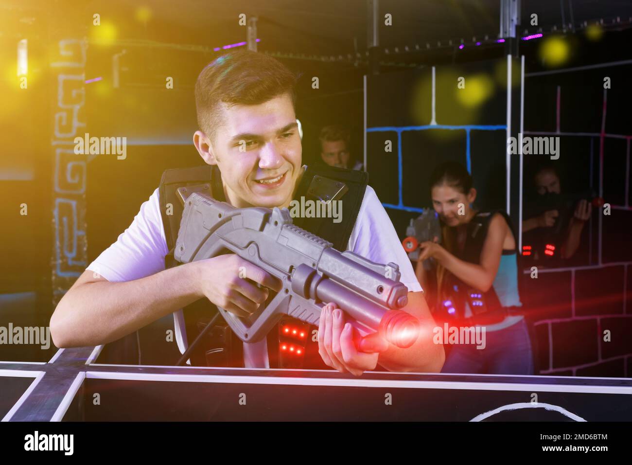 Excited guy holding laser pistol and playing laser tag with his Stock ...