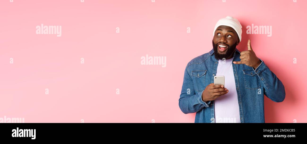 Happy Black man showing call me sign, making phone gesture and smiling ...
