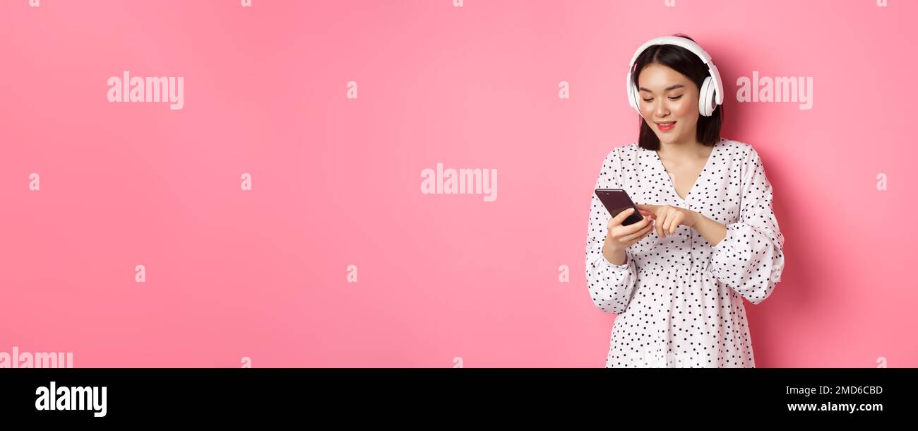 Beautiful asian woman texting message on smartphone, listening music in ...