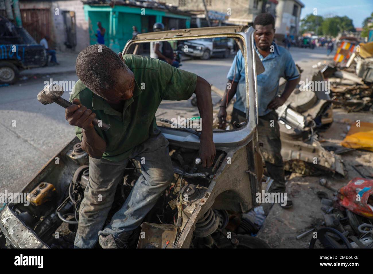 A man dismantles a car in Port-au-Prince, Haiti, Wednesday, Oct. 27 ...