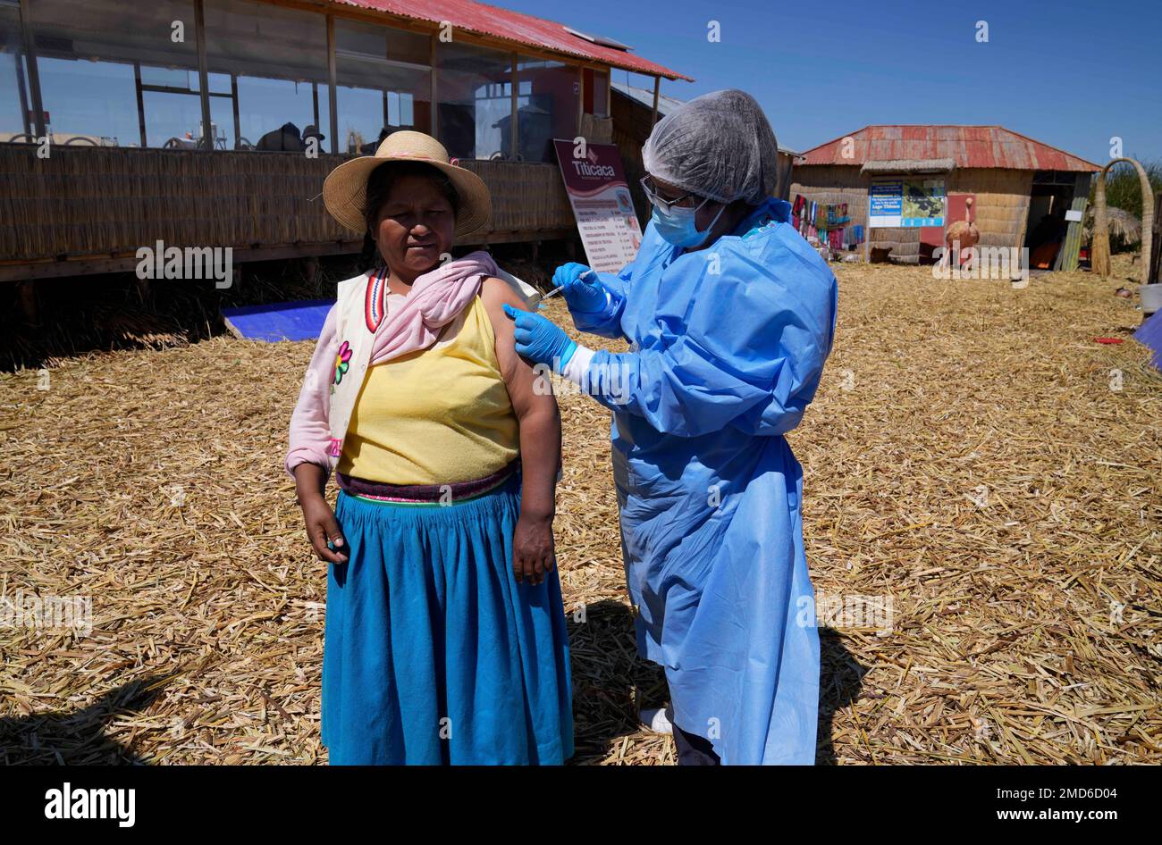 A healthcare worker injects Julia Suana with a dose of the Pfizer COVID ...