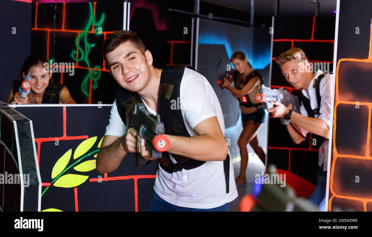 Portrait of excited guy with laser pistol playing laser tag in a Stock ...